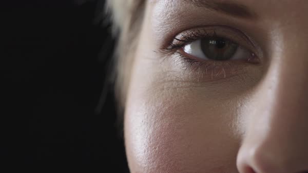 Close up of young woman eye looking at camera smiling happy isolated on ...