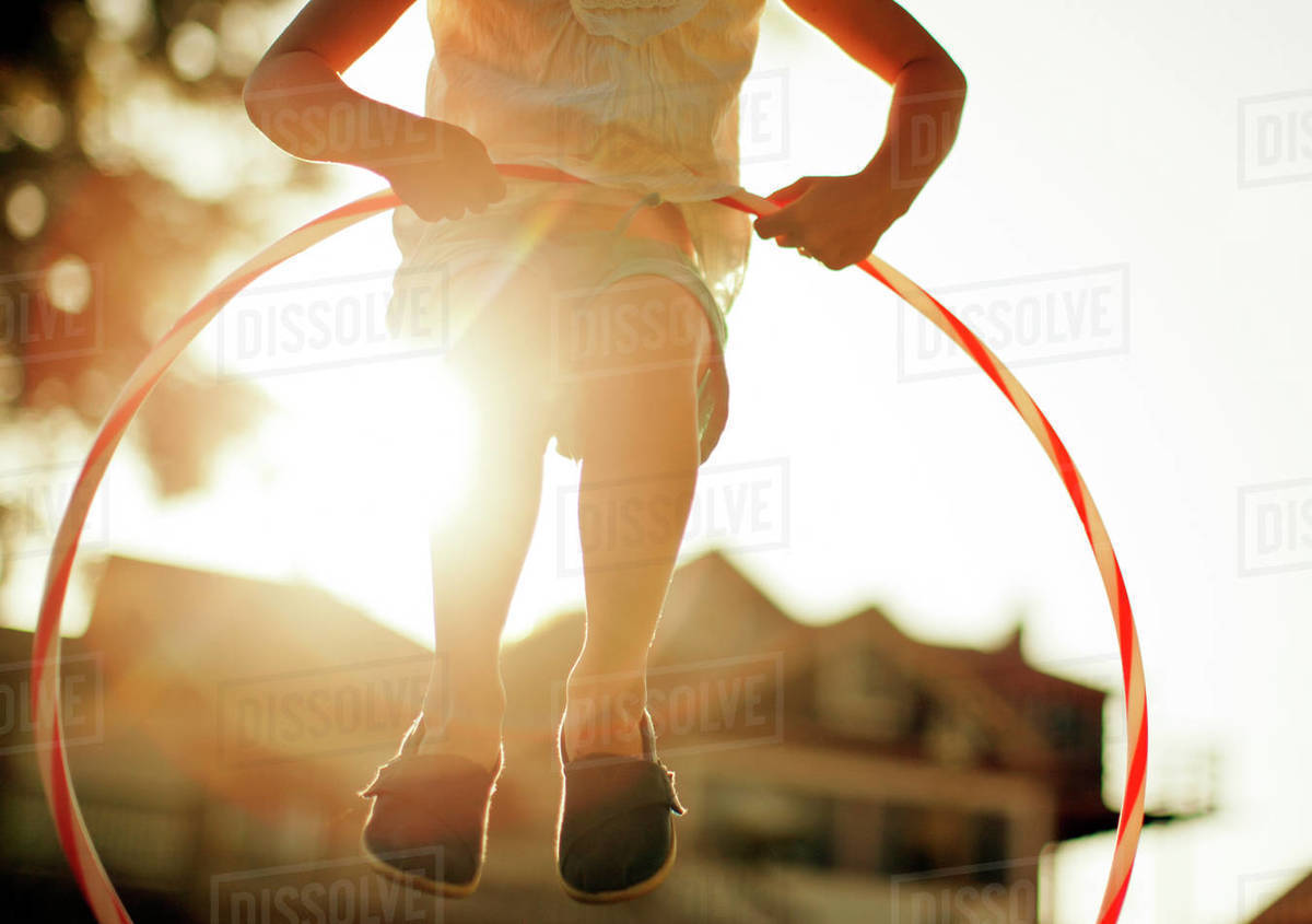 Young girl jumping through a hula hoop. - Royalty-free Stock Photo ...