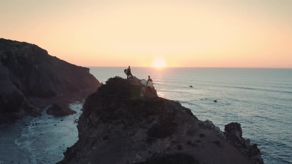 Amazing aerial shot of woman and man surfers standing at the edge of ...