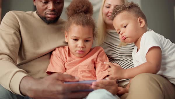 Family of four using smartphone together at home. - Stock Video Footage ...