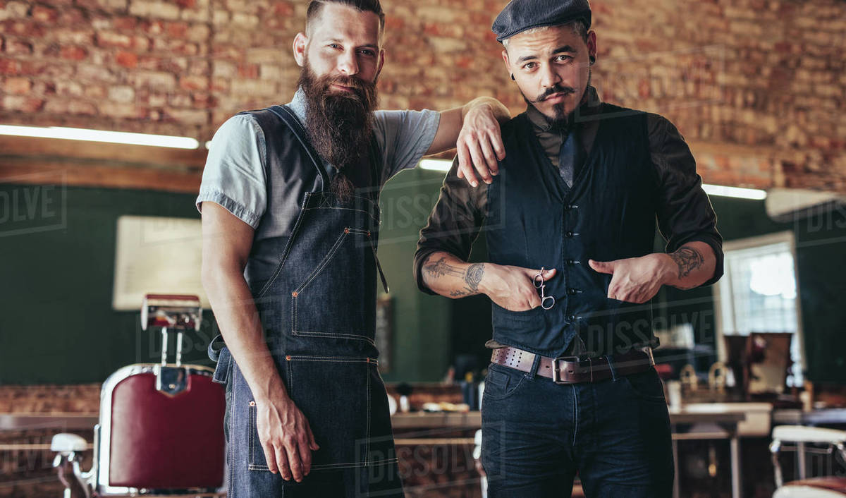 Shot of barber with stylish young man standing at salon. Two men ...