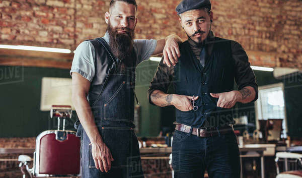Shot of barber with stylish young man standing at salon. Two men ...