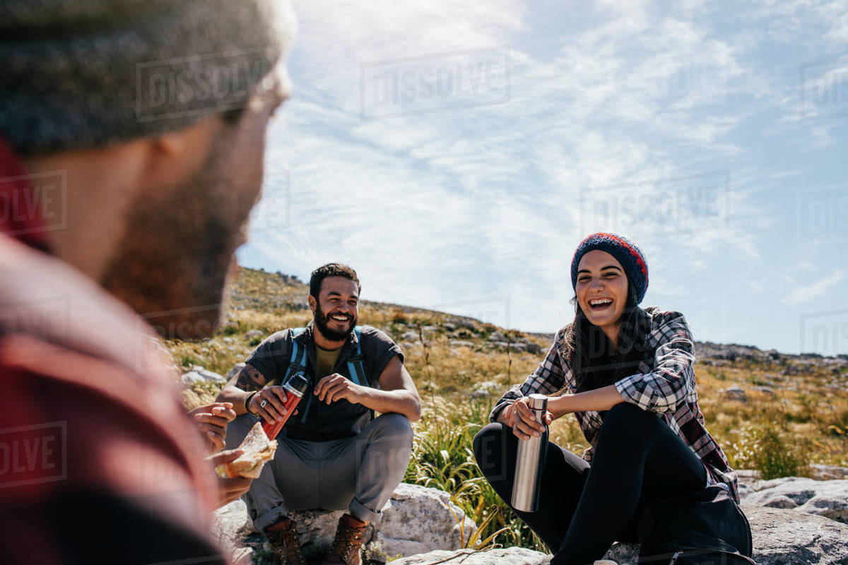 Group of people taking a break, relaxing during a hike. Young woman ...