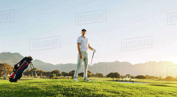 Full length of young caucasian man standing on golf course on a summer ...