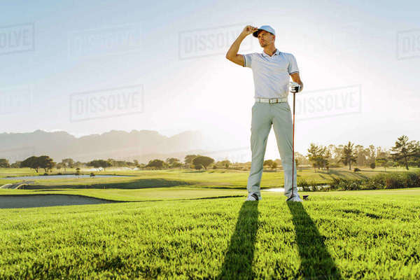 Full length of professional male golfer standing on golf course on a ...