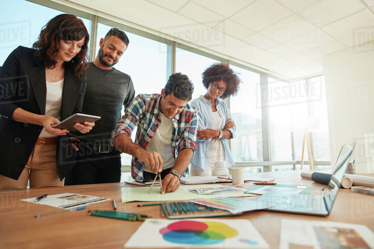 Team of young professionals working together in creative office ...