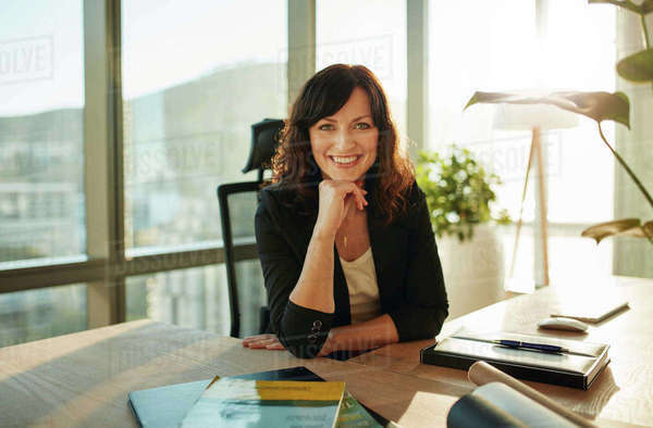 Portrait of smiling businesswoman sitting at her desk. Beautiful female ...