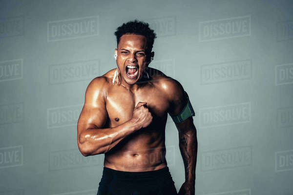 Shirtless male model with muscular physique shouting. Aggressive young ...