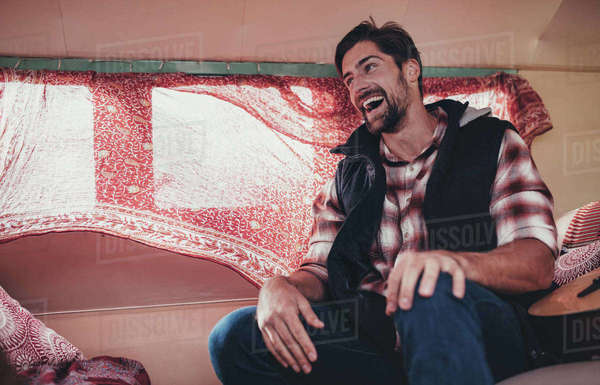 Caucasian man sitting inside the van and laughing. Smiling male on a ...