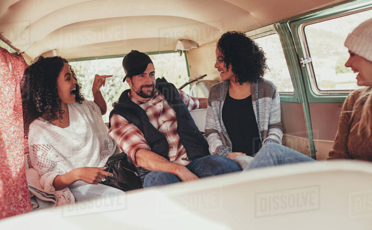 Diverse friends on roadtrip travelling together in a van. Group of man ...