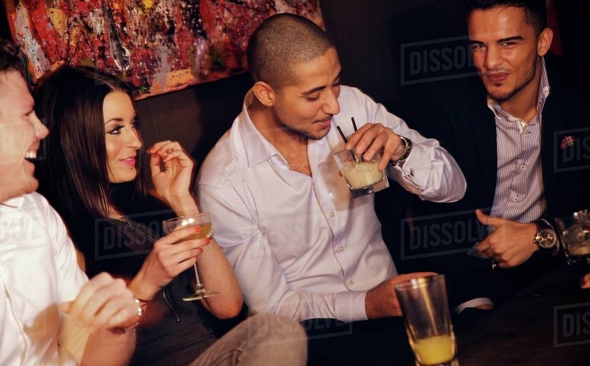 Group of men having fun together with their pretty female friend at the ...