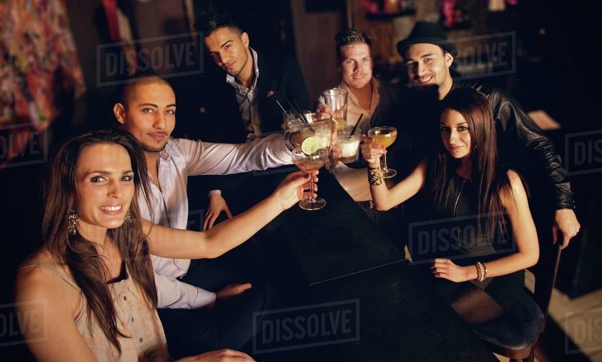 Group of friends at the bar raising their glass for a toast - Stock ...