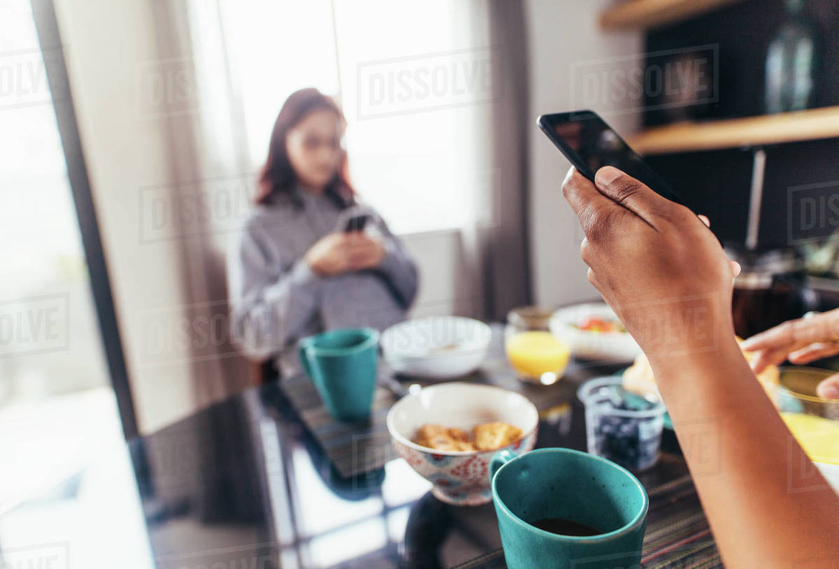 Close up of man hand holding mobile phone while having breakfast with ...