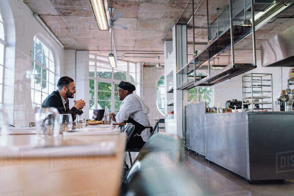 Business manager and chef talking in restaurant. Restaurant owner and ...