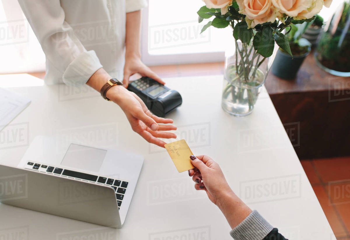 Close up of hand offering credit card for payment at checkout in flower ...