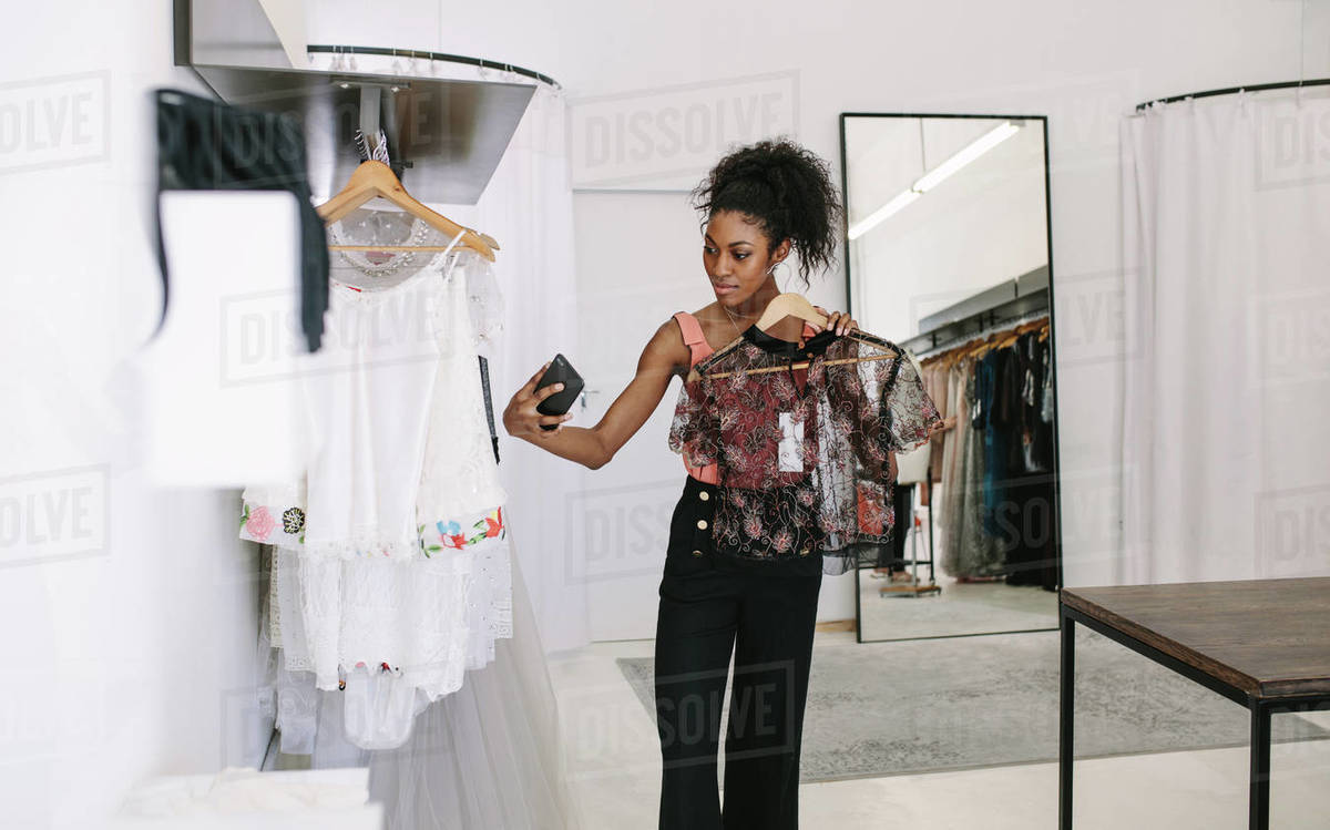 Fashion designer taking a selfie with a designer dresses in her fashion ...