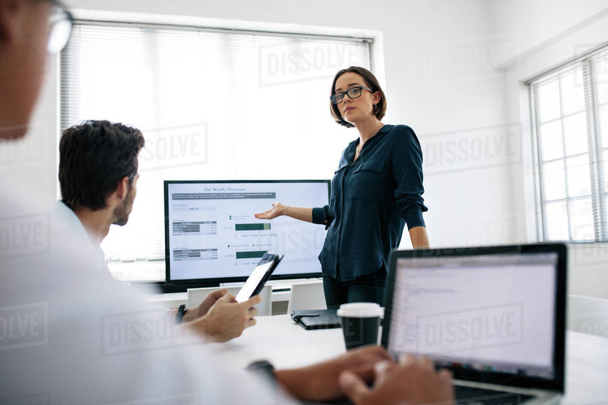 Businesswoman wearing spectacles making a presentation to her ...