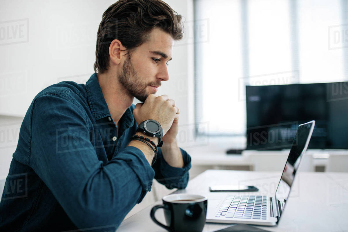Software developer sitting in front of computer and working in office ...