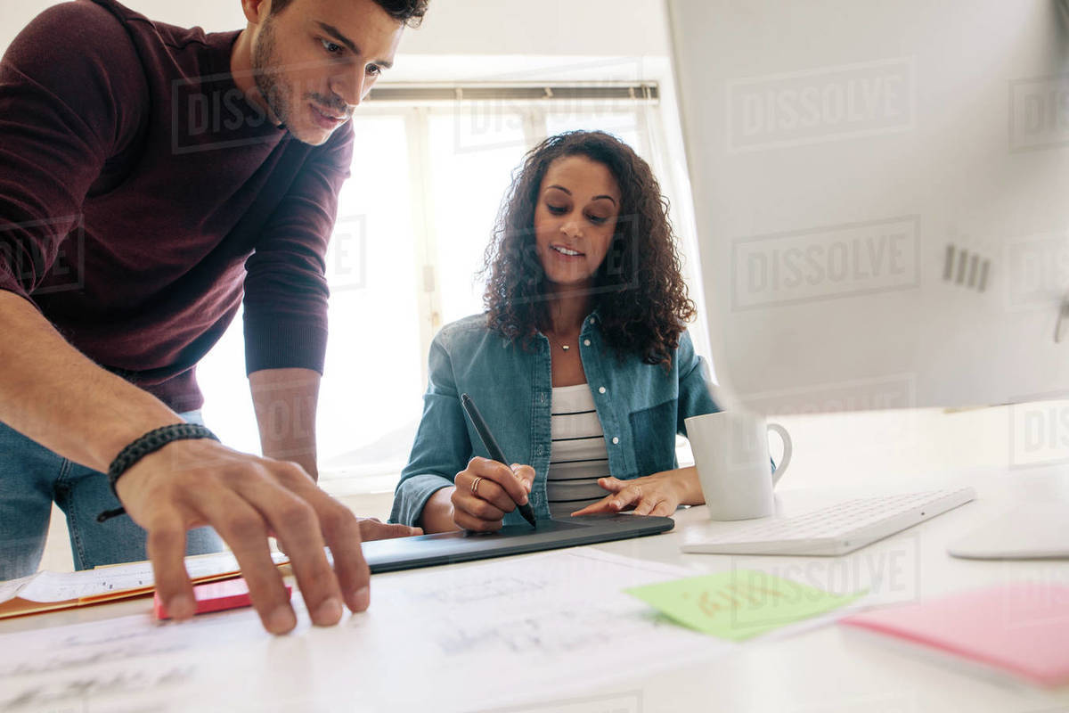 Businessman looking at business papers while the woman is writing on ...