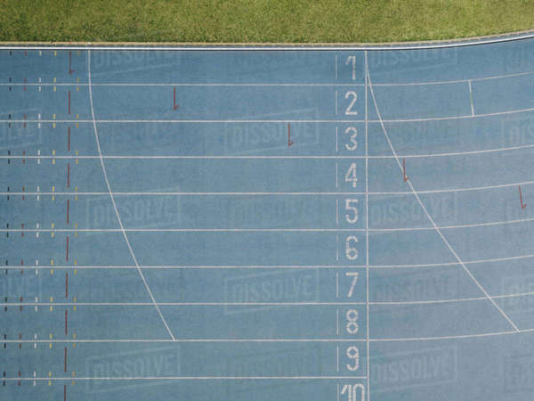 Aerial view of finish line of an athletic track. Top view of blue all ...