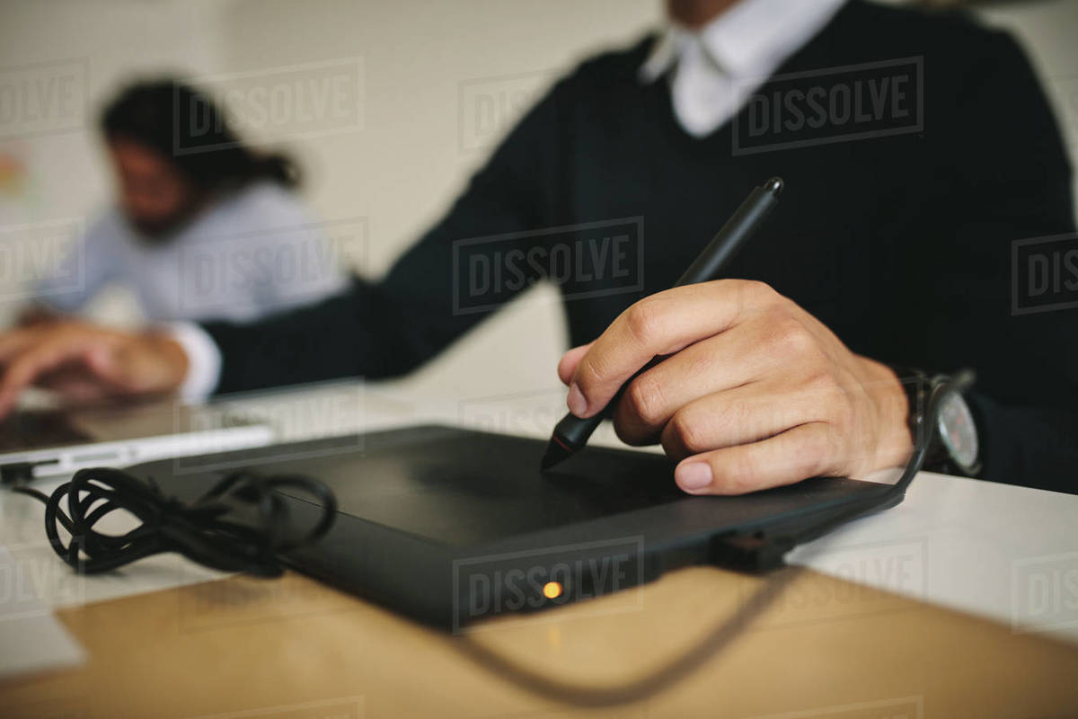 Close up of a man writing on a digital writing pad using a digital pen ...