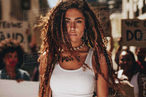 Strong young female activist protesting outdoors with group of women in ...