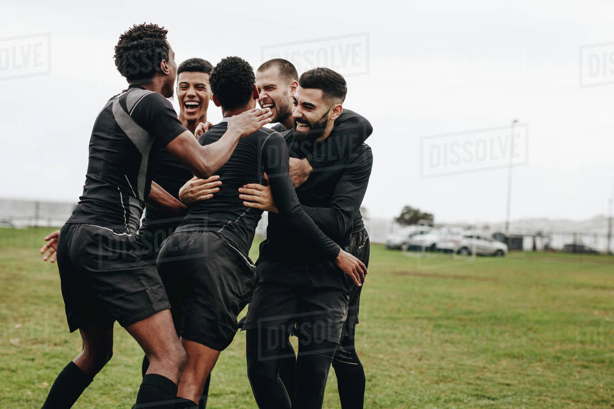 Group of football players excited on scoring a goal. Footballers coming ...