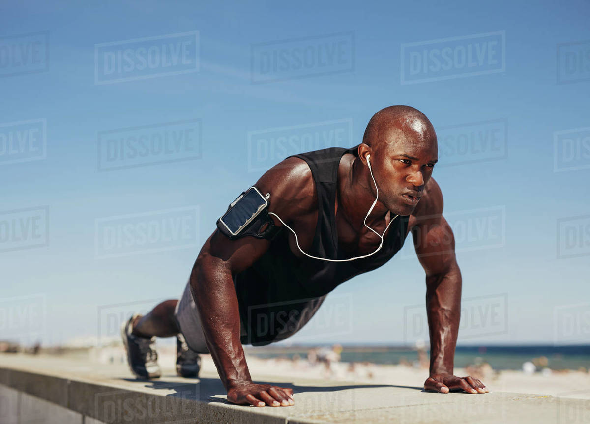 Young athletic man doing push-ups. Fitness model doing outdoor workout ...