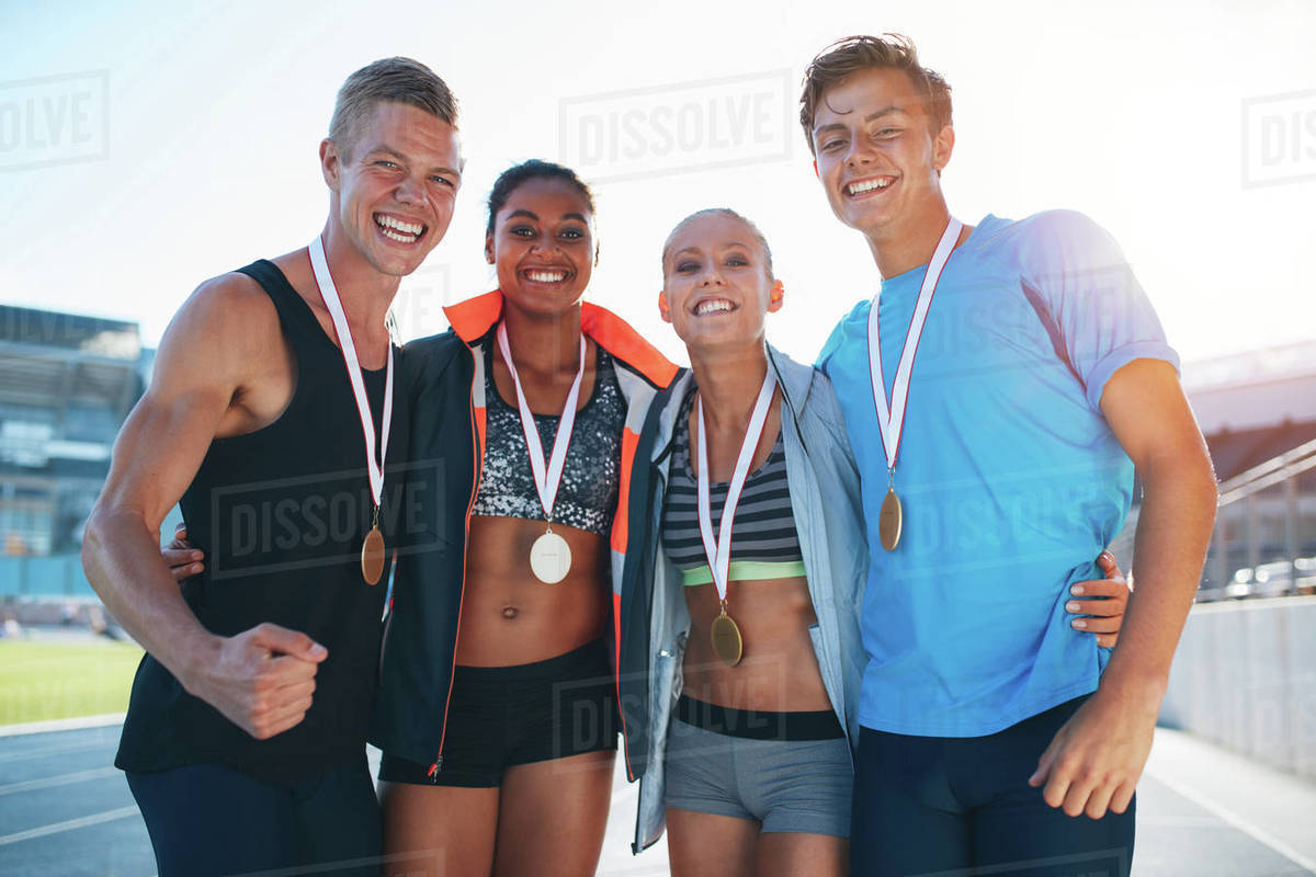 Happy multiracial athletes celebrating victory while standing together ...