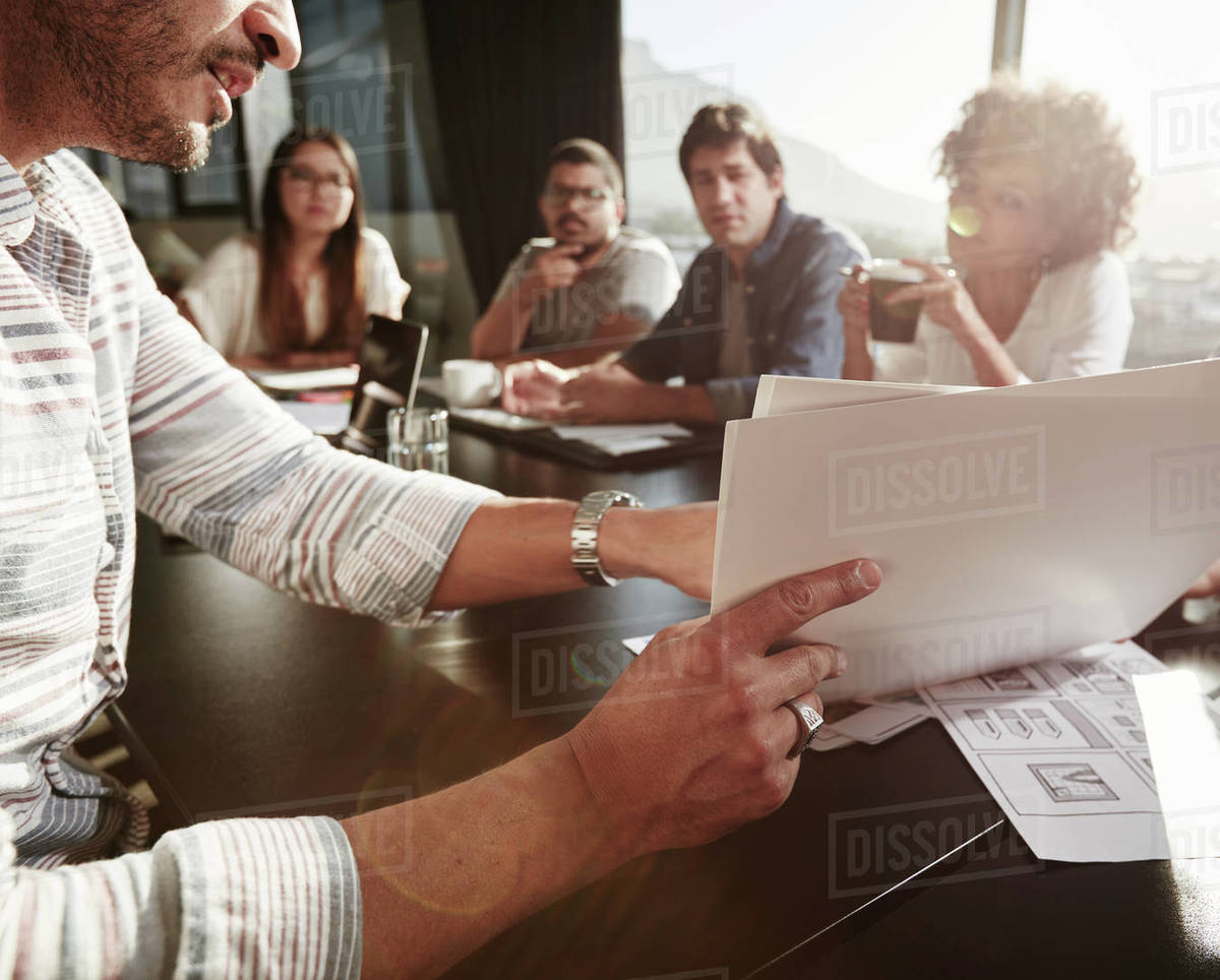 Closeup of hands of young man explaining business plan to colleagues ...