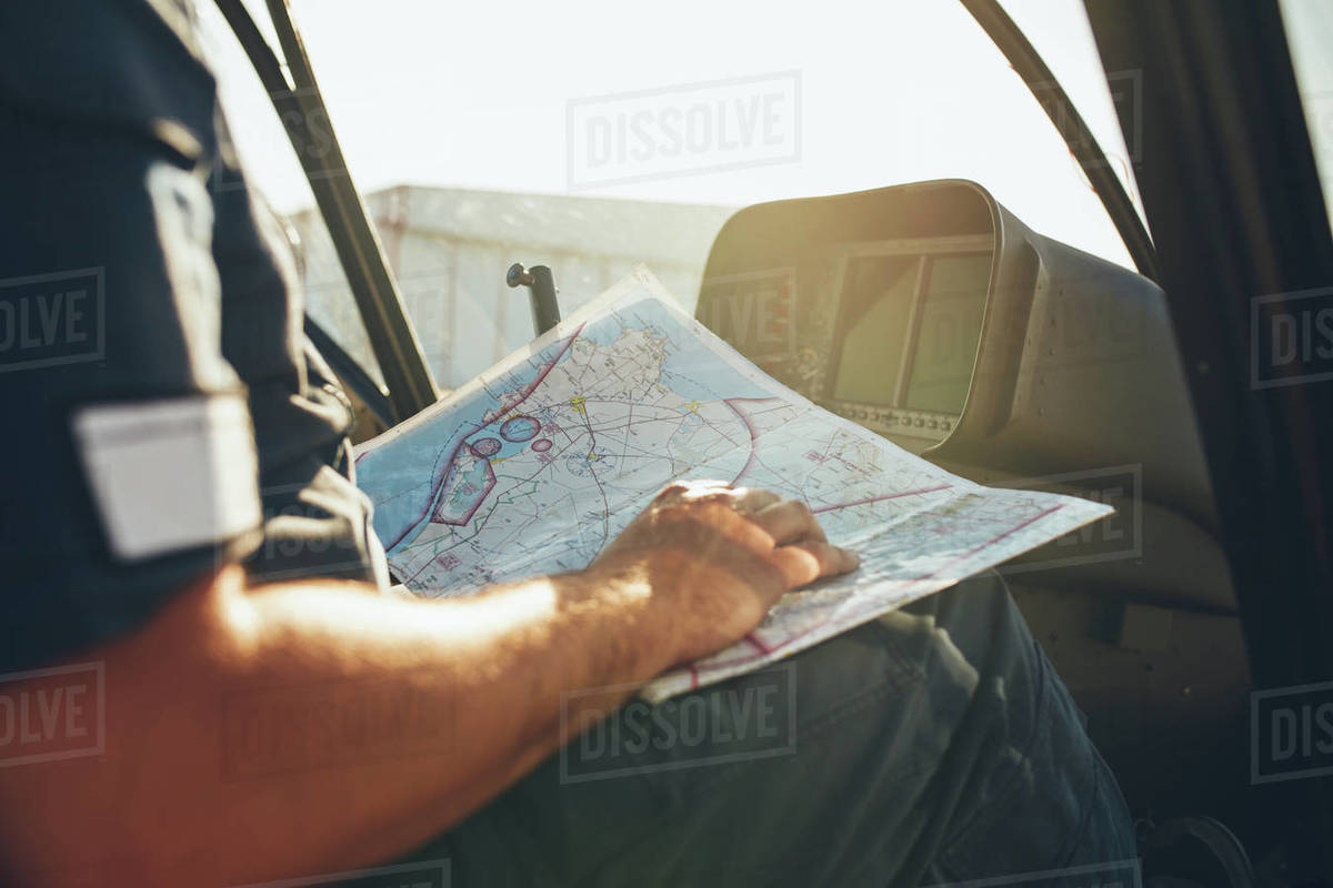 Close up shot of a helicopter pilot studying the flight route map while ...