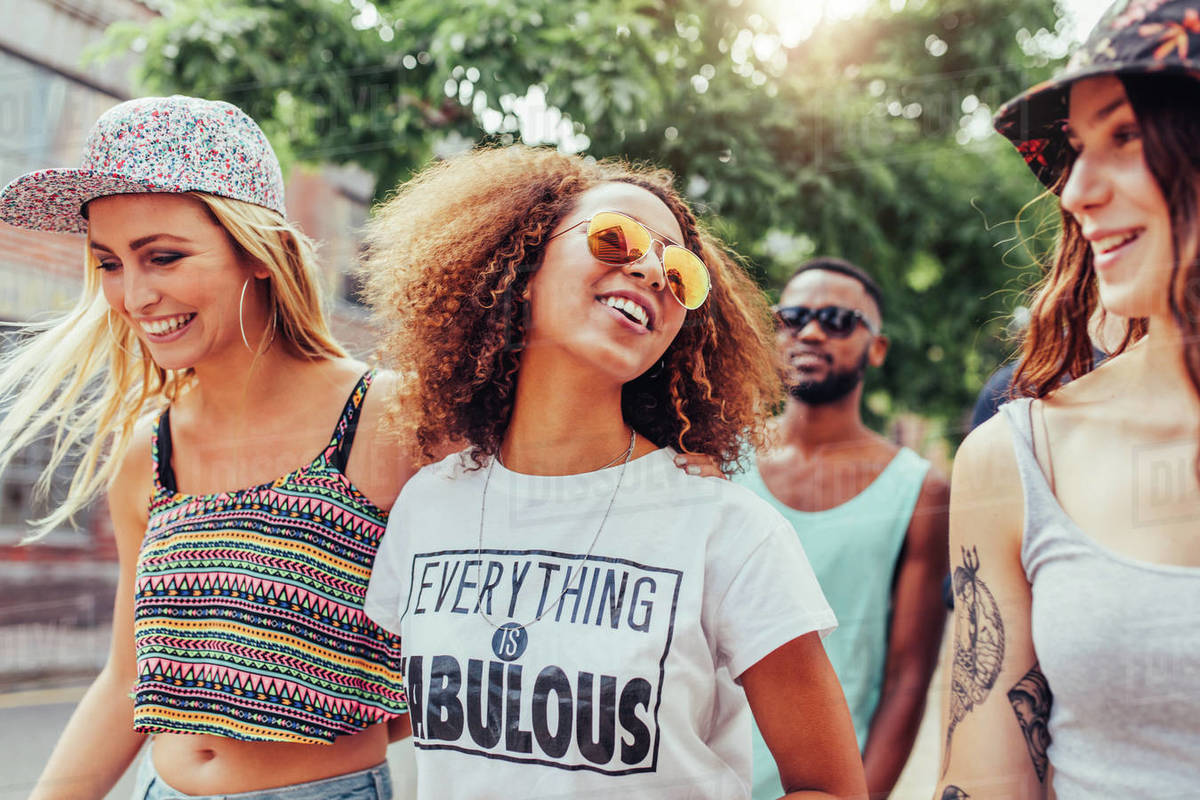Closeup portrait of mixed race young people walking together outdoors ...