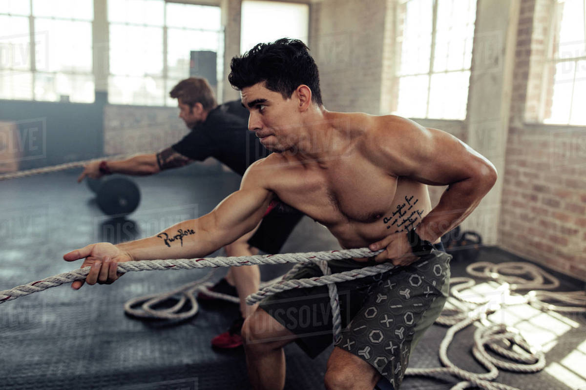 Two young muscular men doing intense crossfit workout. Crossfit pulling ...