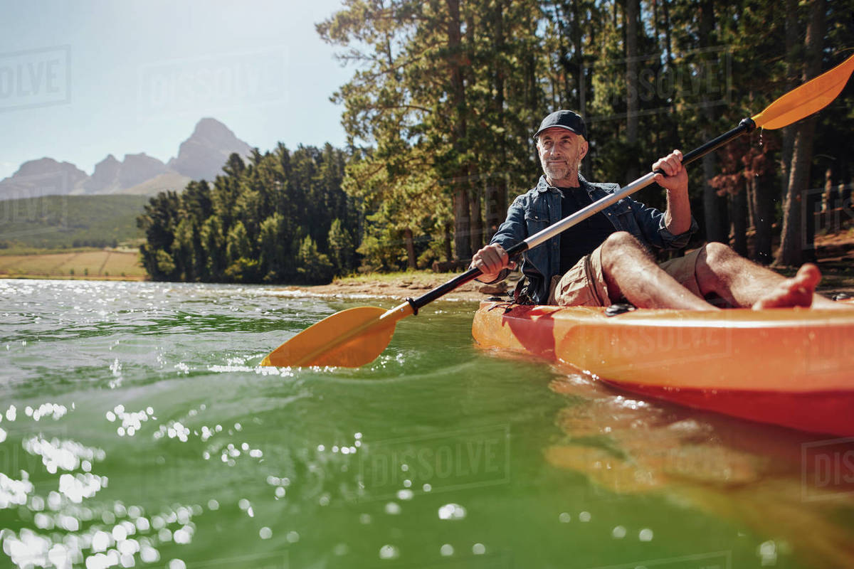 Portrait of a mature man with enjoying kayaking in a lake. Caucasian ...