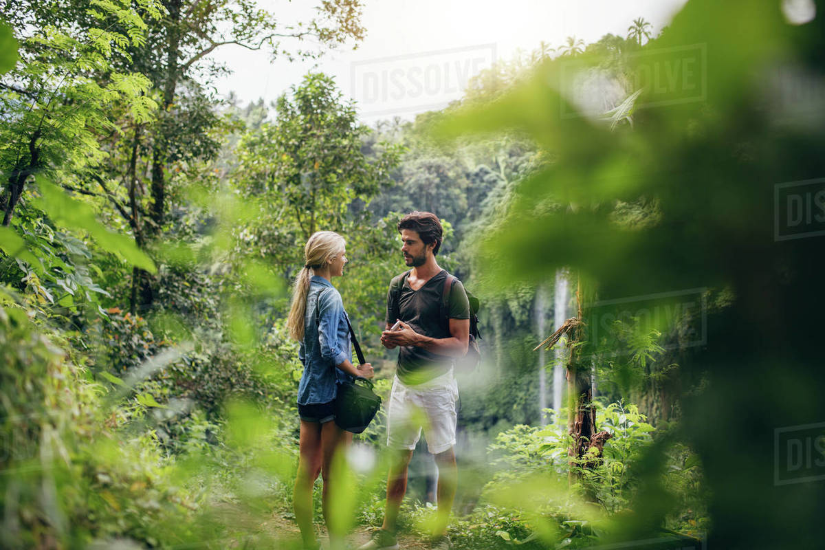 Outdoor shot of young man and woman standing together on a cliff and ...