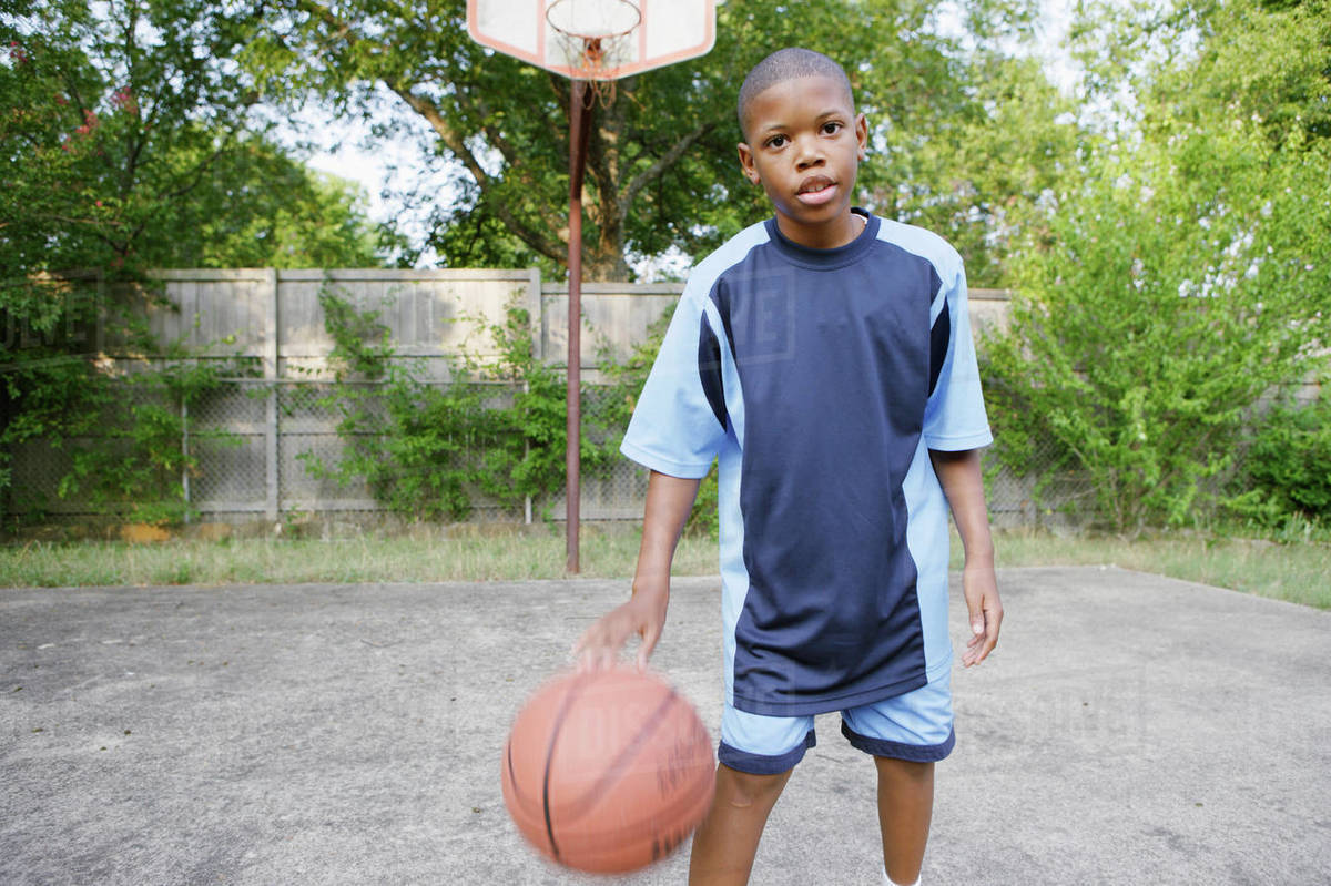 Young boy dribbling basketball - Royalty-free Stock Photo | Dissolve