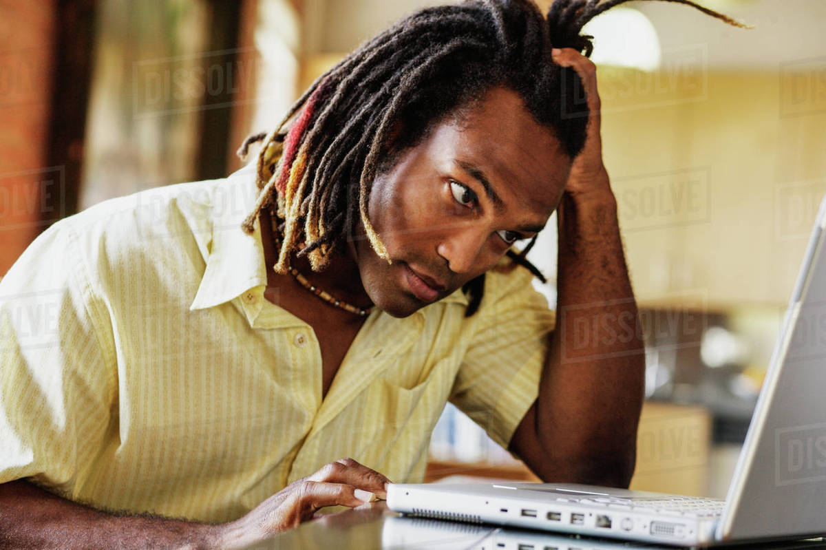 Man with hand on head while working on laptop - Royalty-free Stock ...