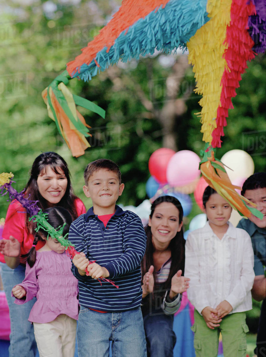 Young boy swinging at a pinata - Royalty-free Stock Photo | Dissolve