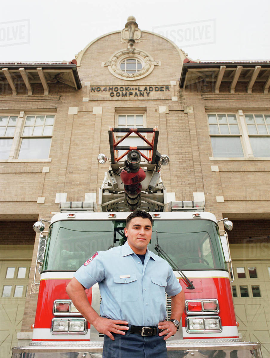 Fireman posing for the camera by fire engine - Stock Photo - Dissolve