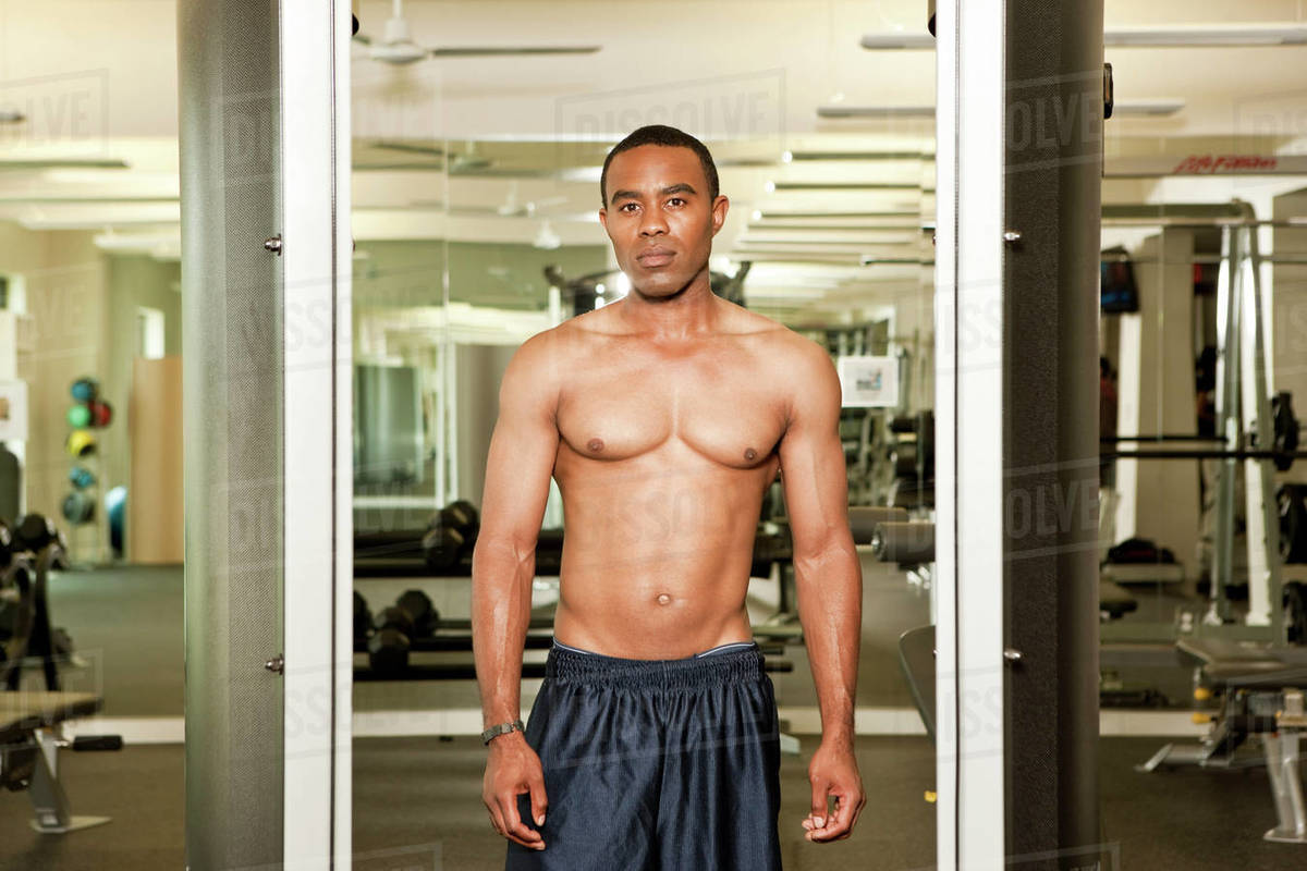 African American man with bare chest posing in health club - Royalty ...