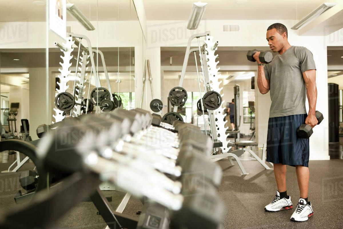 African American man lifting hand weights in health club - Royalty-free ...