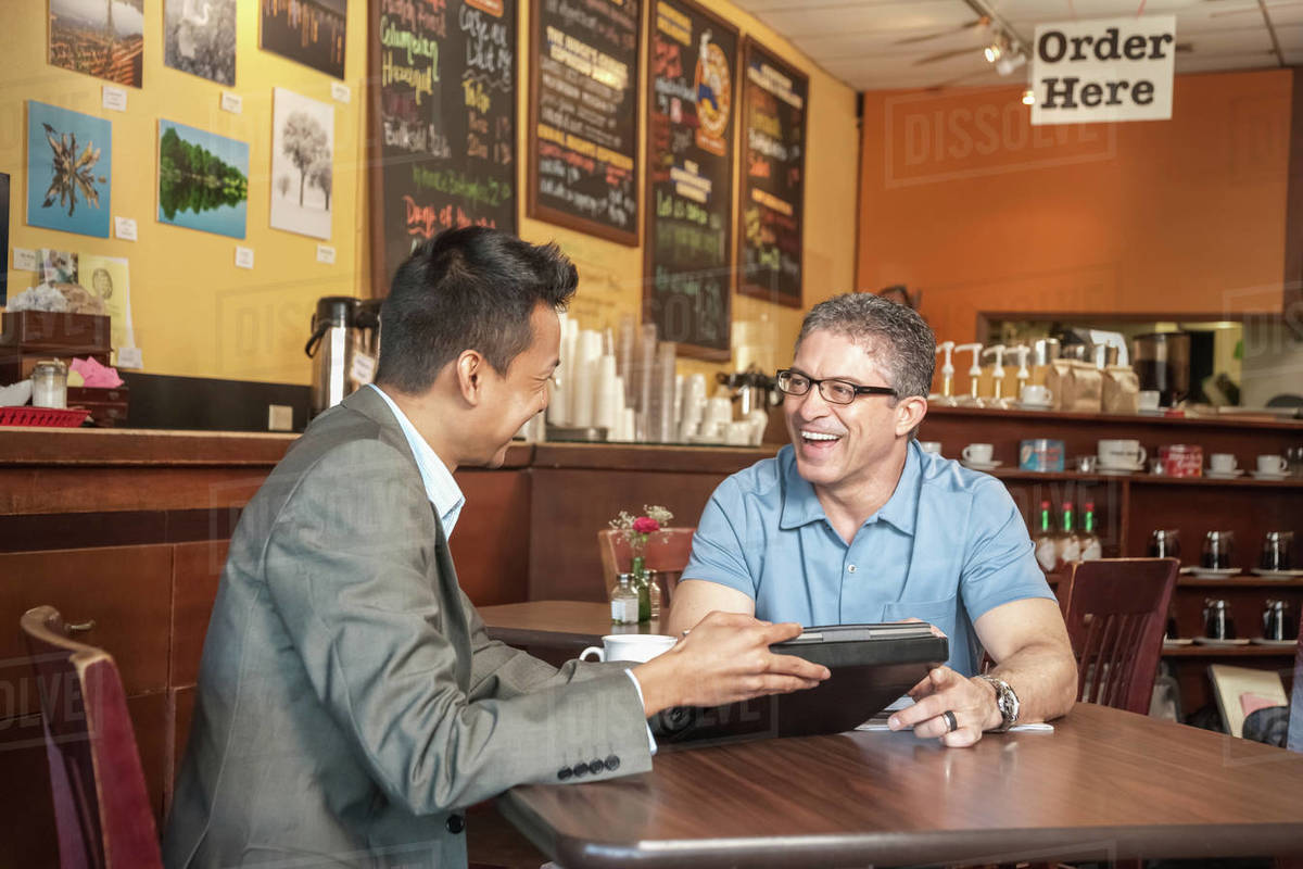 Salesman talking to owner in cafe - Royalty-free Stock Photo | Dissolve
