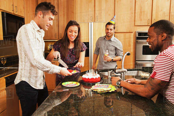 Friends having birthday cake in kitchen - Royalty-free Stock Photo ...