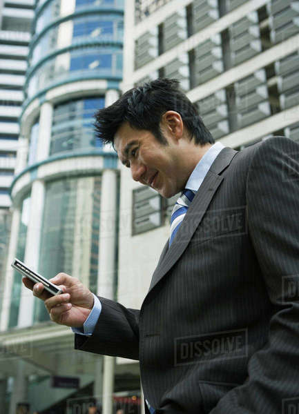 Chinese businessman text messaging on cell phone - Royalty-free Stock ...