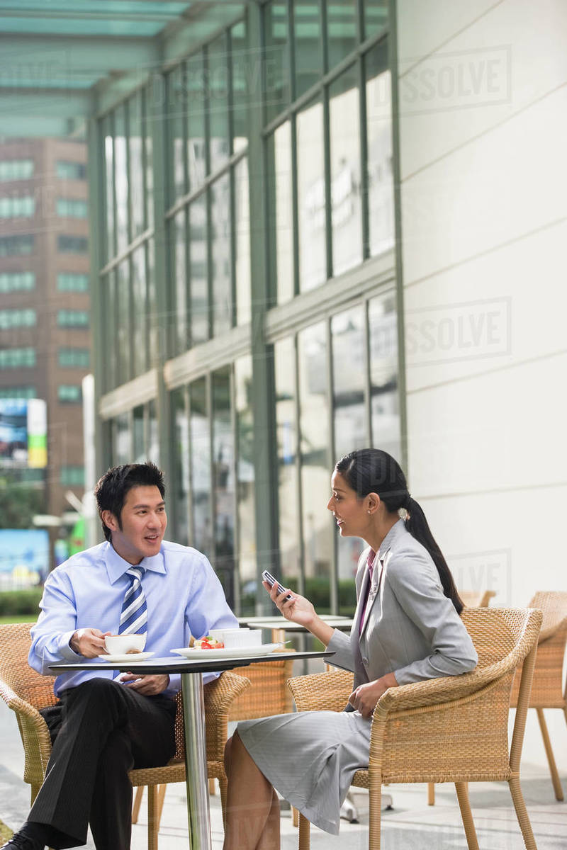 Business people talking in cafe - Royalty-free Stock Photo | Dissolve