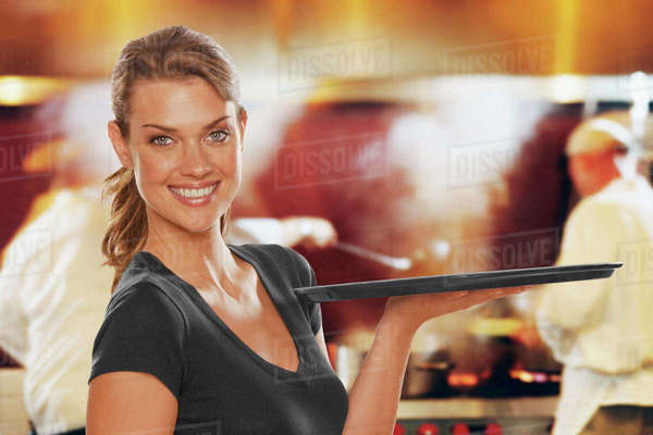 Smiling Caucasian waitress carrying tray - Royalty-free Stock Photo ...