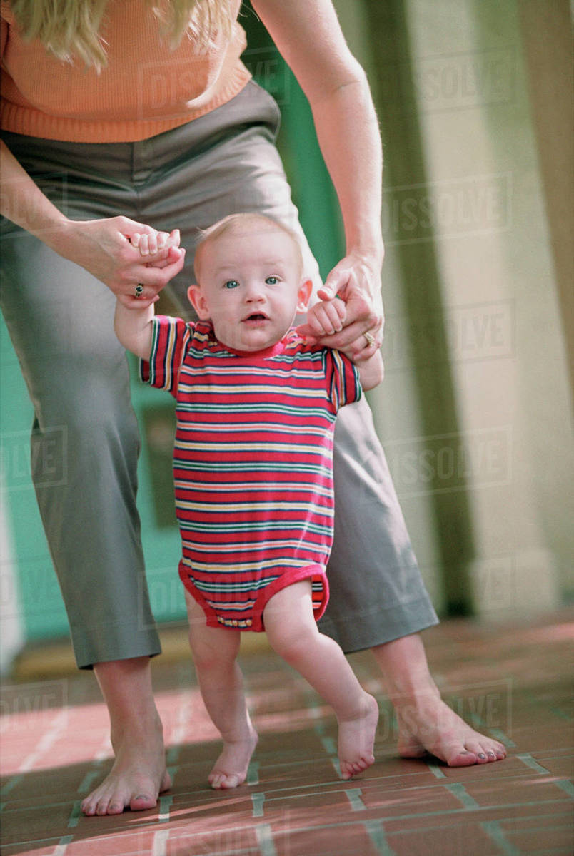 Baby walking with mother's help - Royalty-free Stock Photo | Dissolve