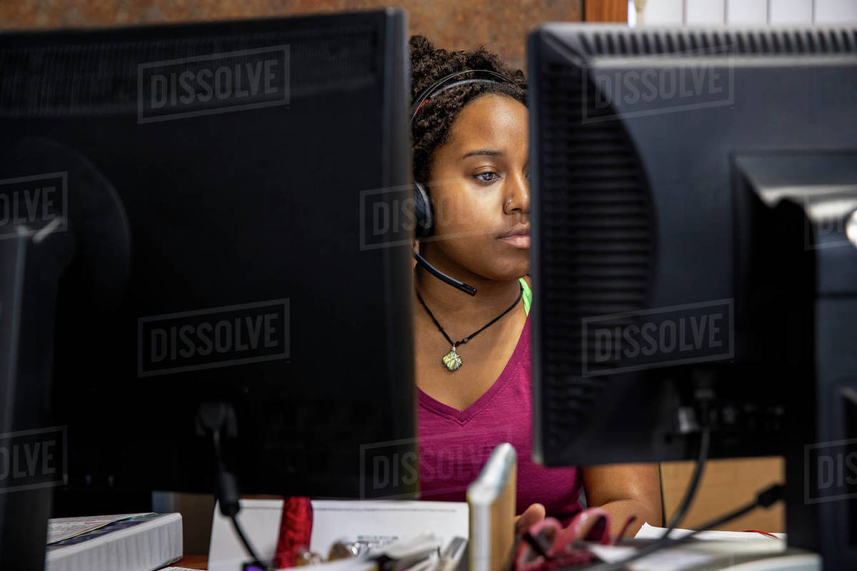 A portrait of an African American woman at her call center desk and her ...