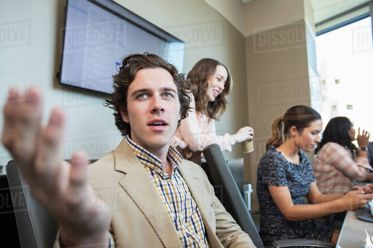 Young man having discussion in conference room with co-workers working ...