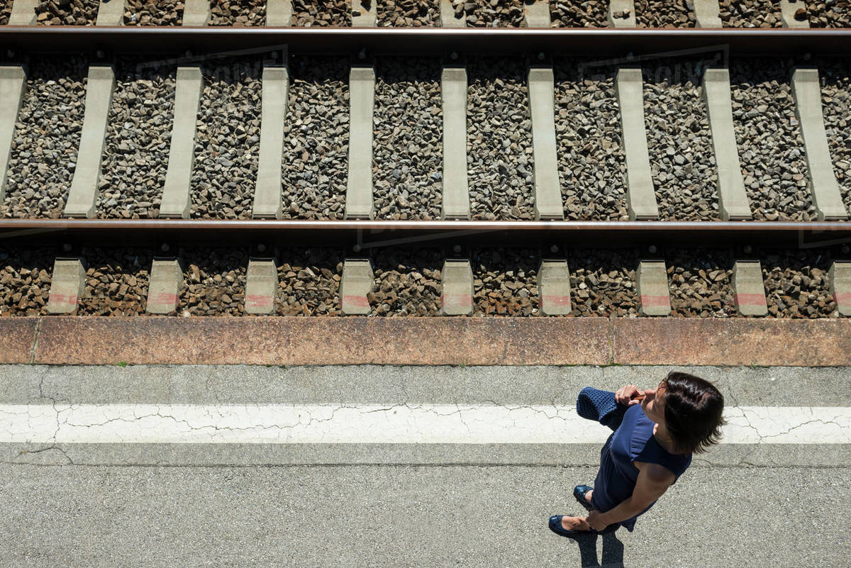 Aerial View of a Woman Waiting on Railroad Station with Tracks in ...